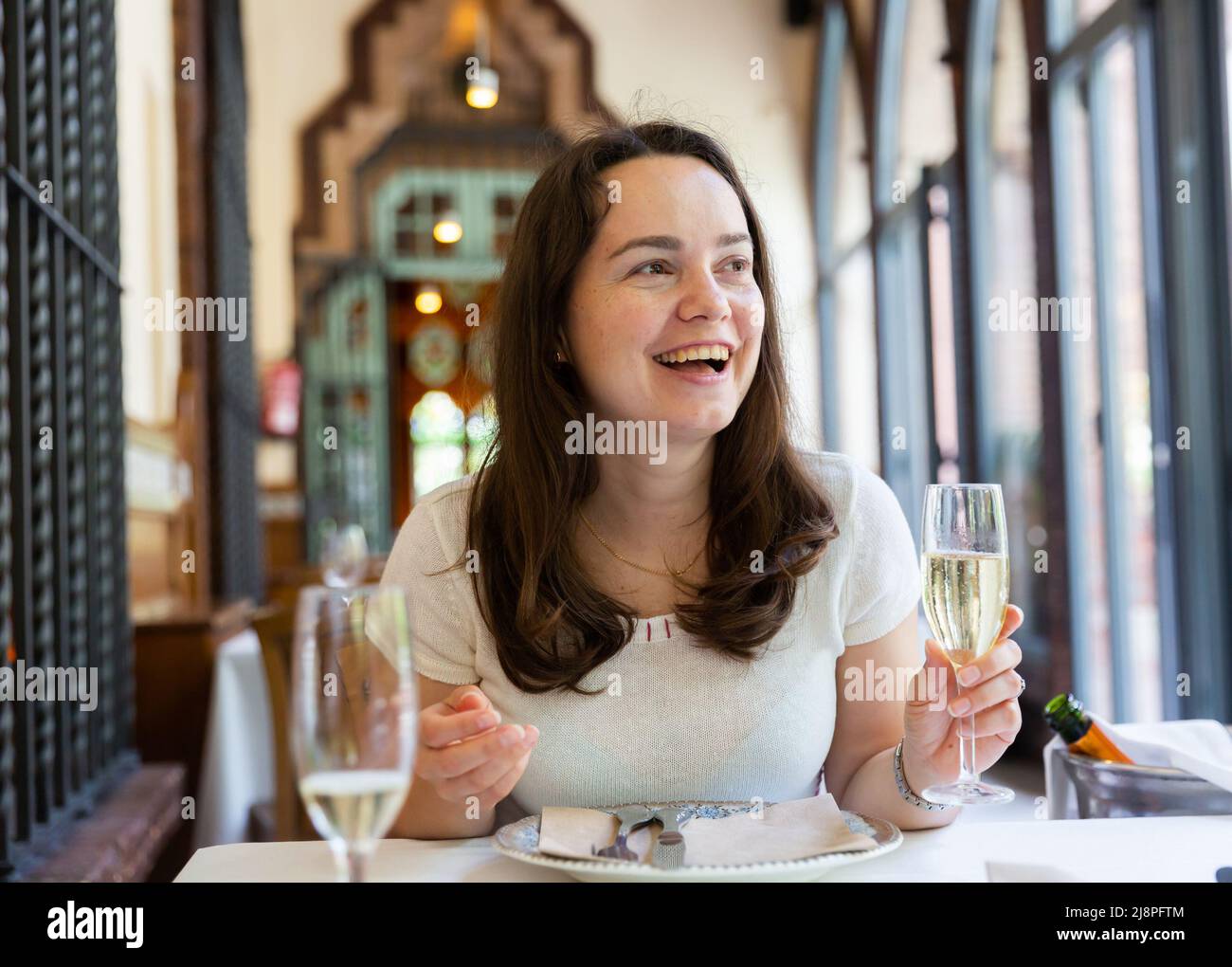 Laughing woman with glass of wine at table in restaurant Stock Photo ...