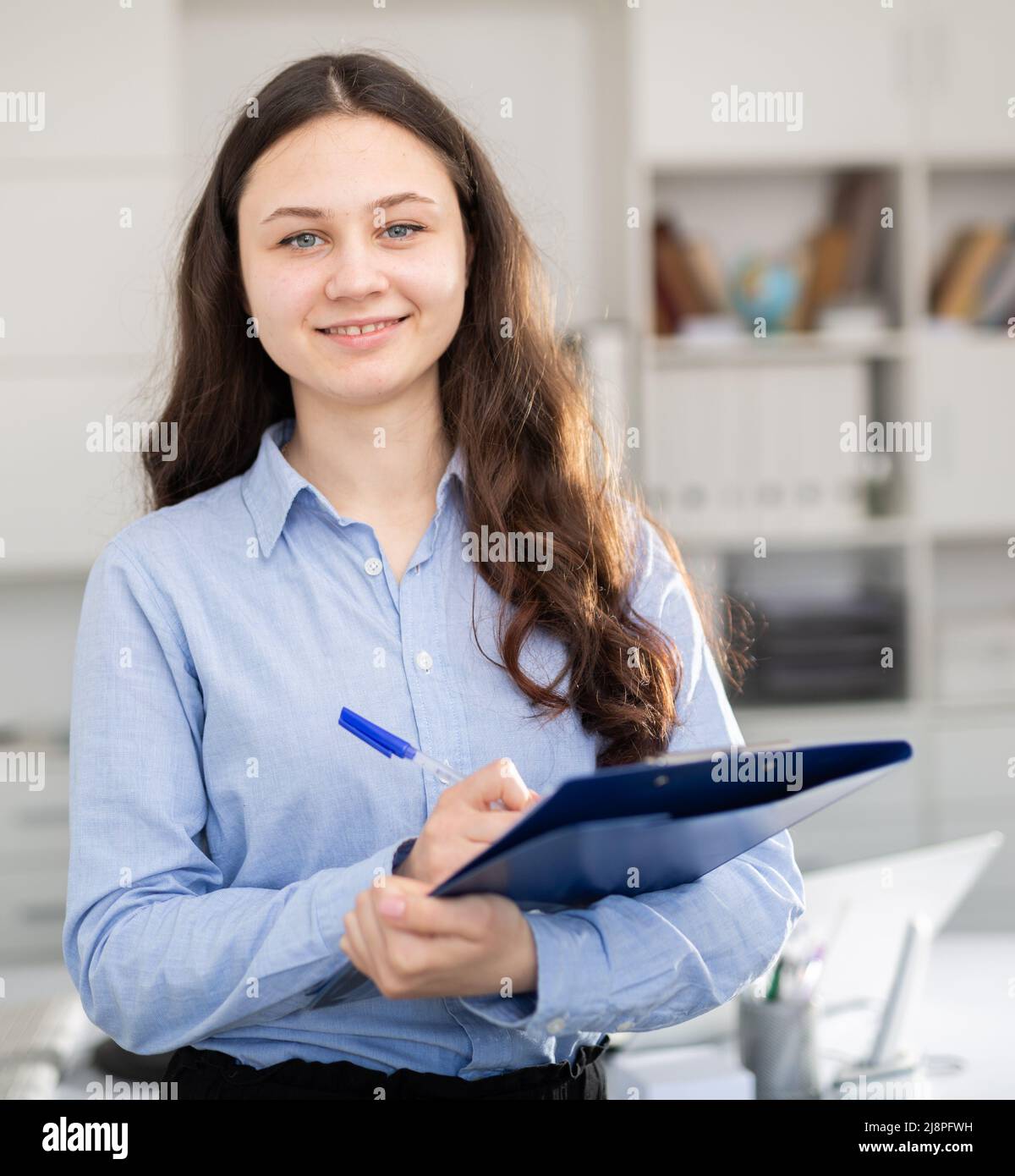 Positive girl secretary with folder for documents in the office Stock ...