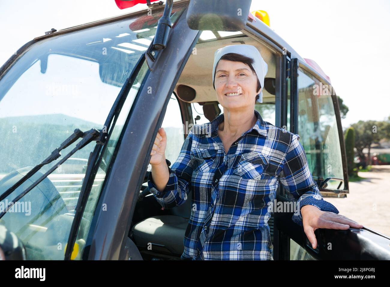 Mature female worker in tractor on farm Stock Photo - Alamy