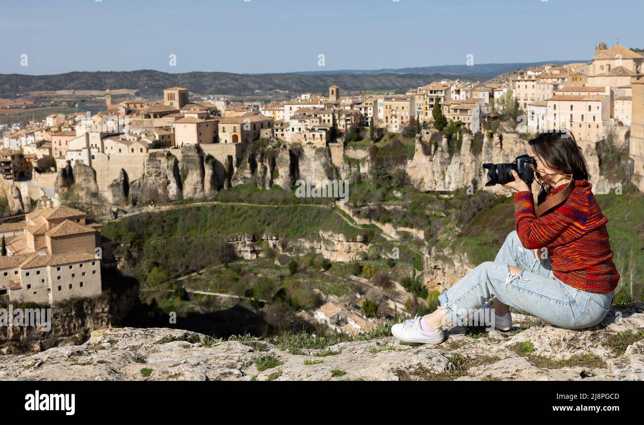 Woman tourist photographs a landscape with a view of the city of Cuenca ...