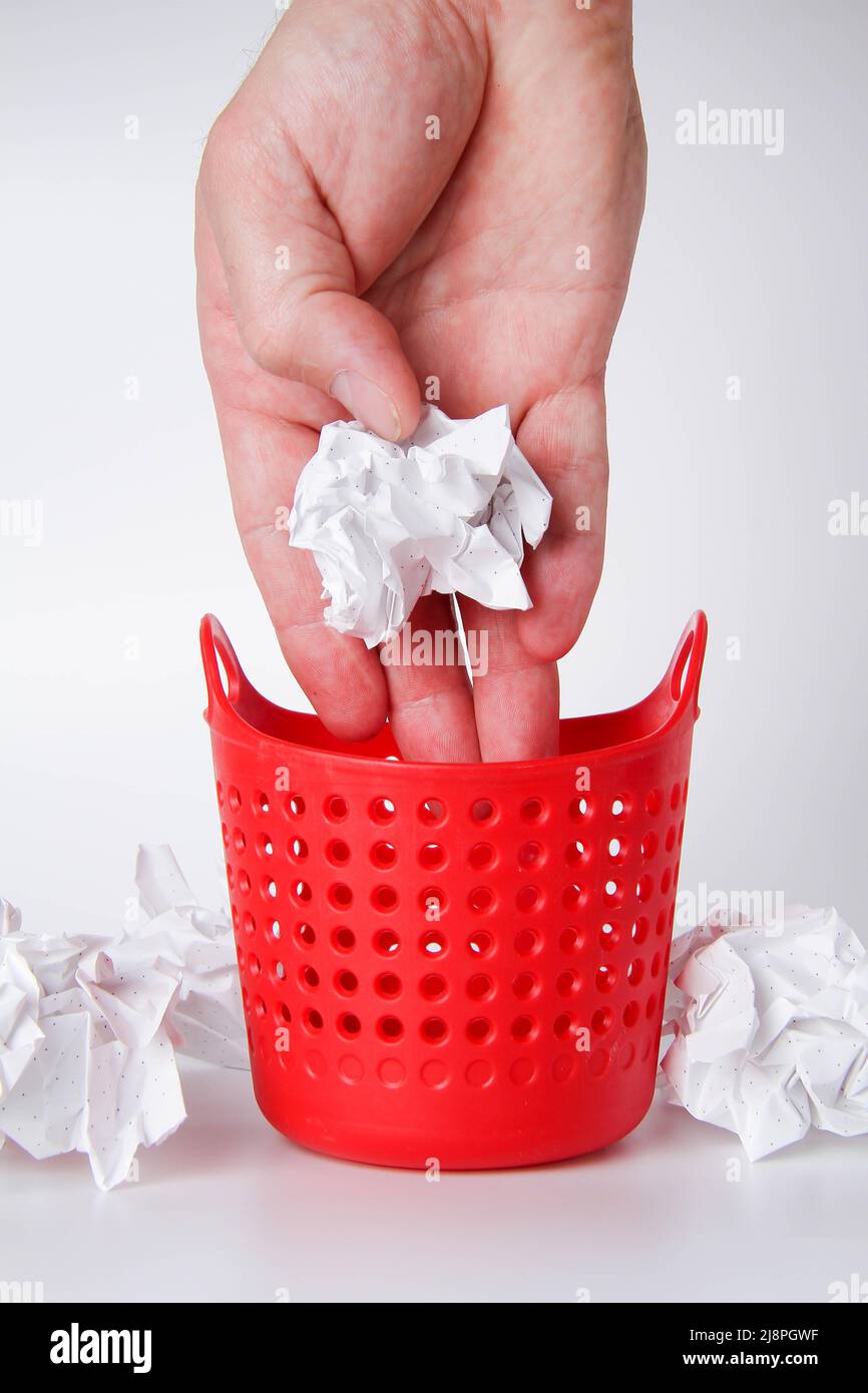 The hand puts the trash in the basket. Workplace cleaning. A man cleans ...