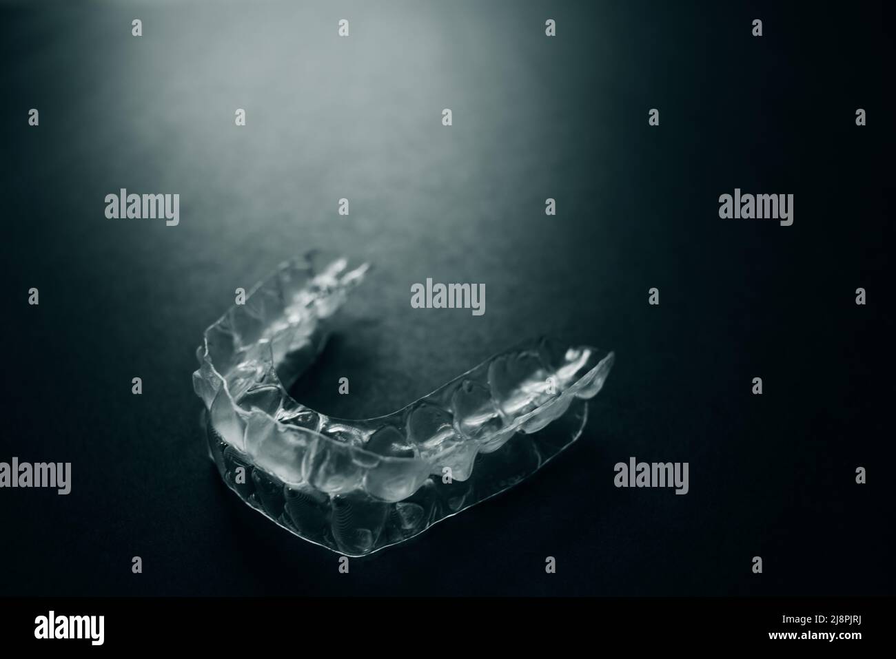 Invisalign braces or invisible retainer on black background. High ...