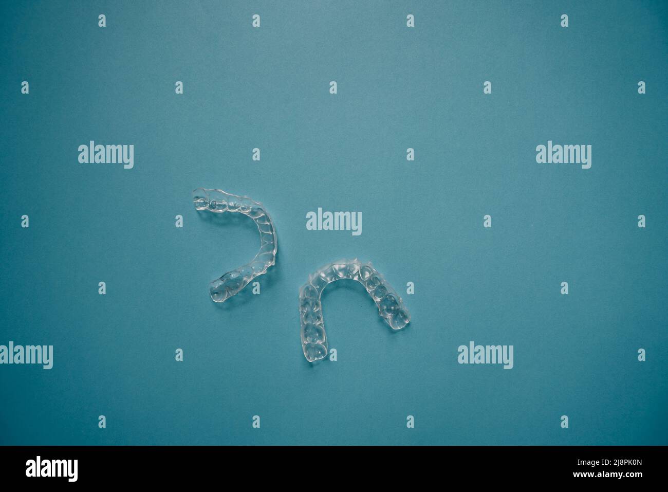 Invisalign braces or invisible retainer on blue background. High ...