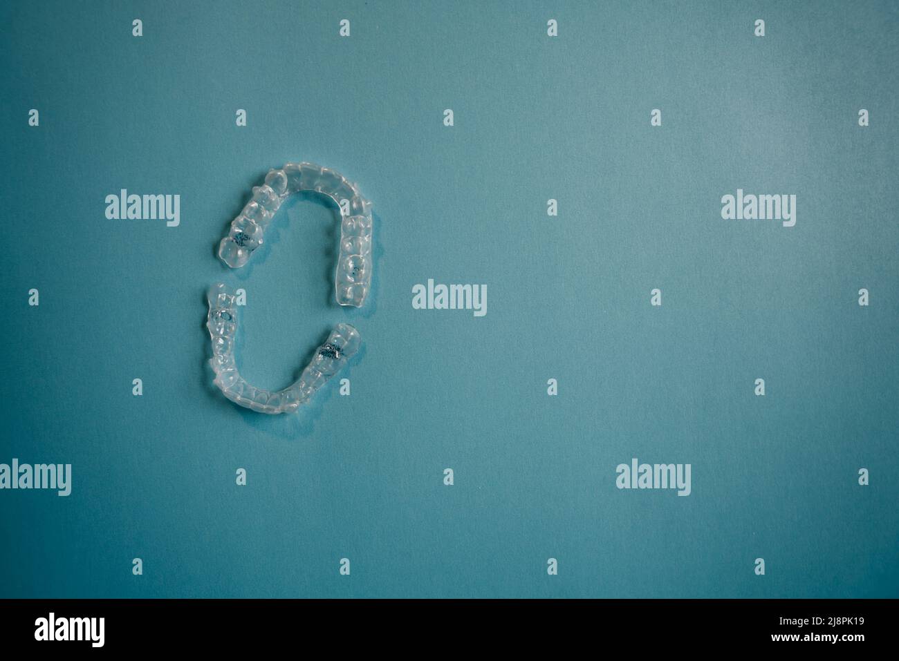 Invisalign braces or invisible retainer on blue background. High ...