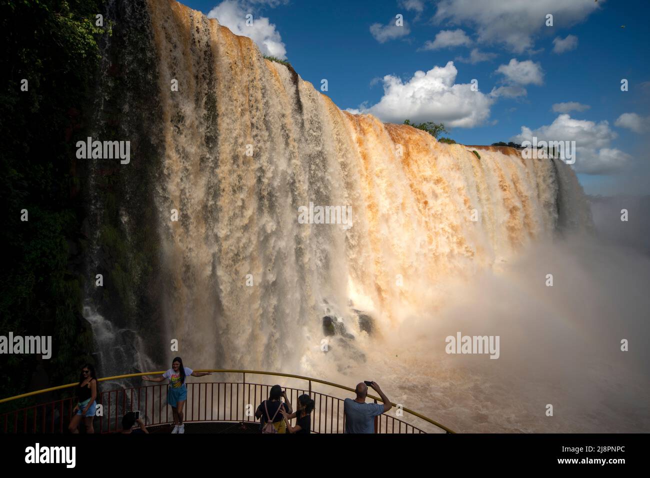 Tourists admiring the Iguazu Falls, one of the biggest falls in the ...