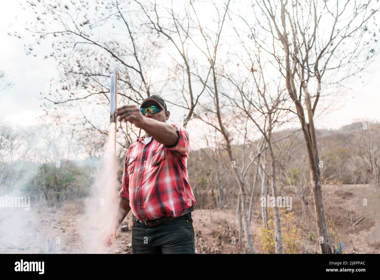 Close-up of a man setting off fireworks during a celebration in rural ...