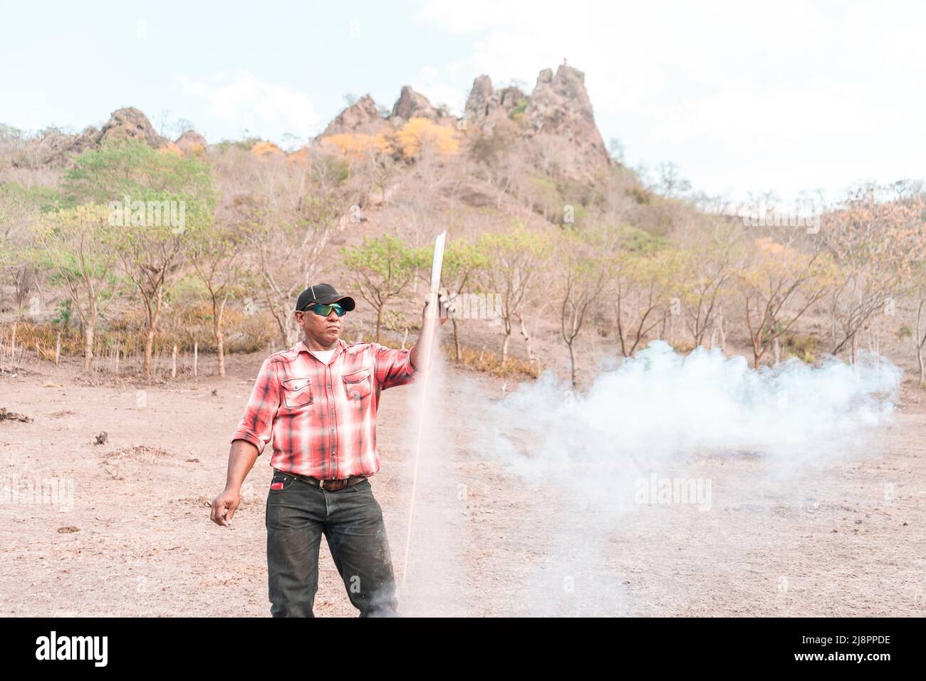 Latin man in a checkered shirt cap and denim pants launching a handmade ...