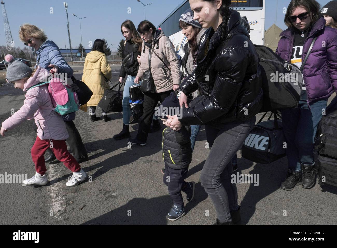 Refugees walk from Krakovets in Ukraine towards the border at Korczowa ...