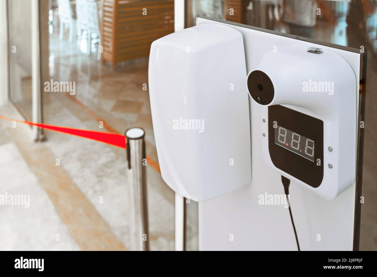 Digital thermometer, infrared scanner in front of the entrance ...