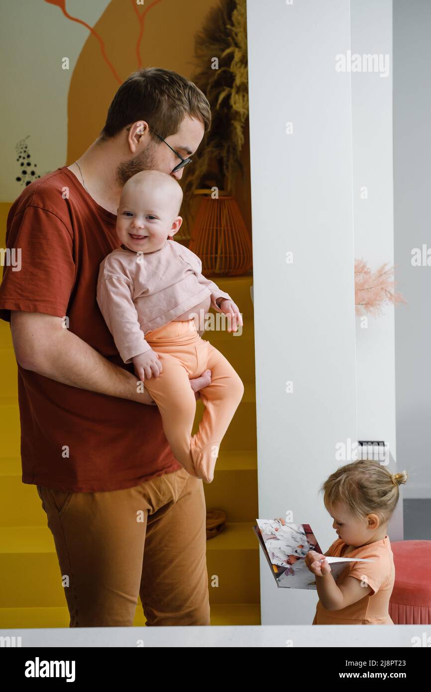Daddy with baby girl in his hands cuddling on the kitchen at home ...