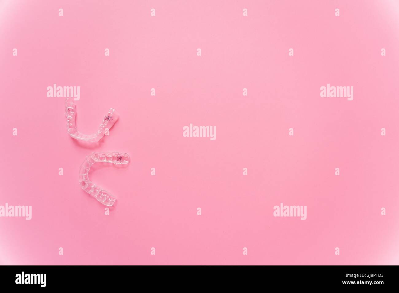 Invisalign braces or invisible retainer on pink background. High ...