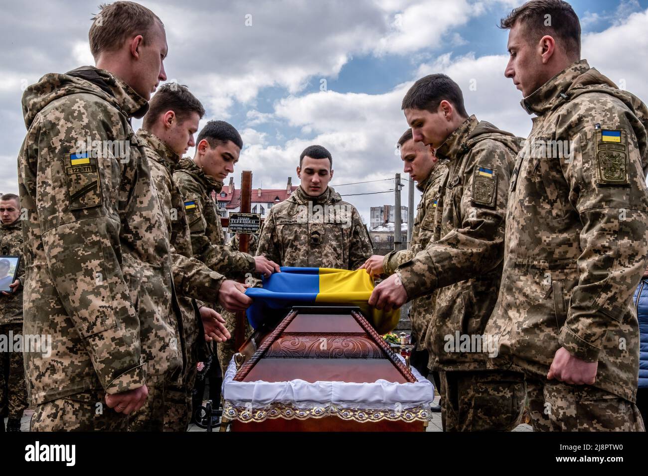 Soldiers cover the coffin of a soldier killed by the Russian army with ...