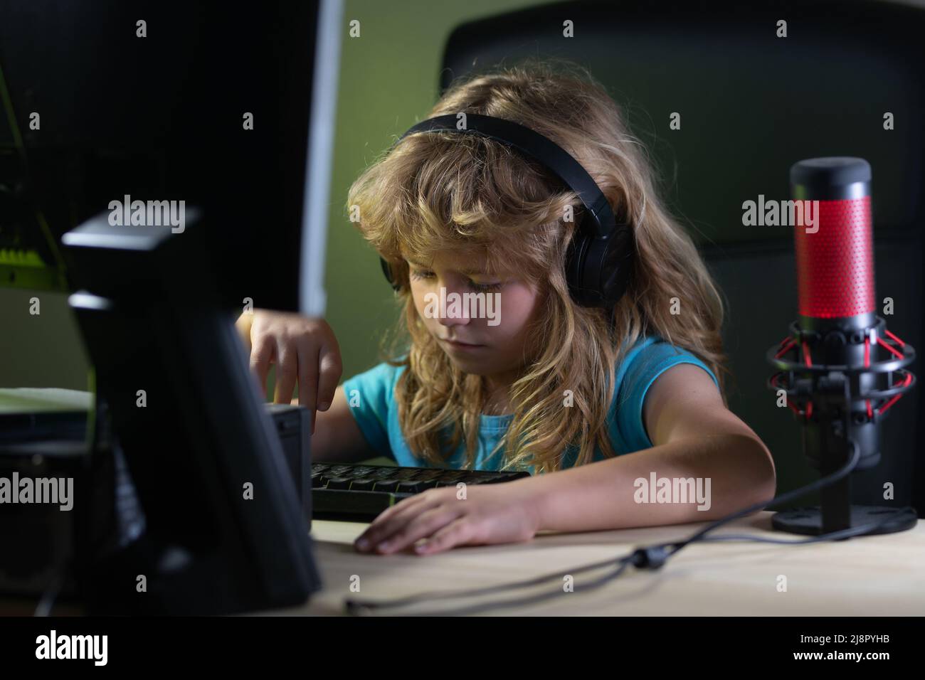 Little child gamer play computer game on desktop. Gaming stream and ...