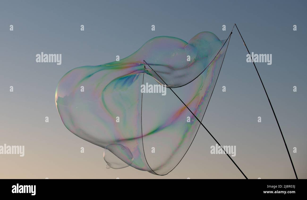 Soap bubbles with rainbow reflection. Buble at the blue sky. Bubble ...