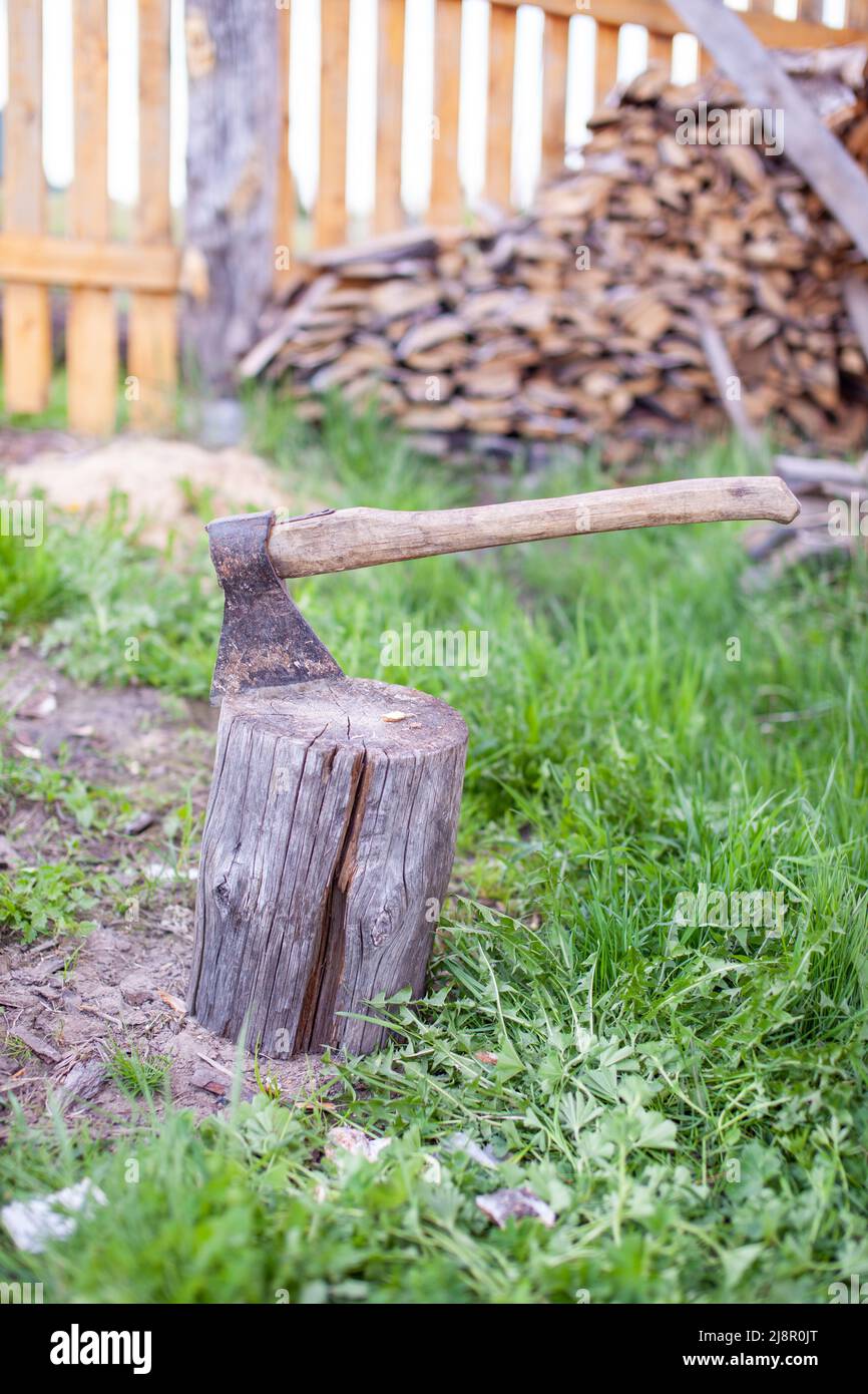 Village life. An axe in a stump or log for chopping firewood. The wood ...