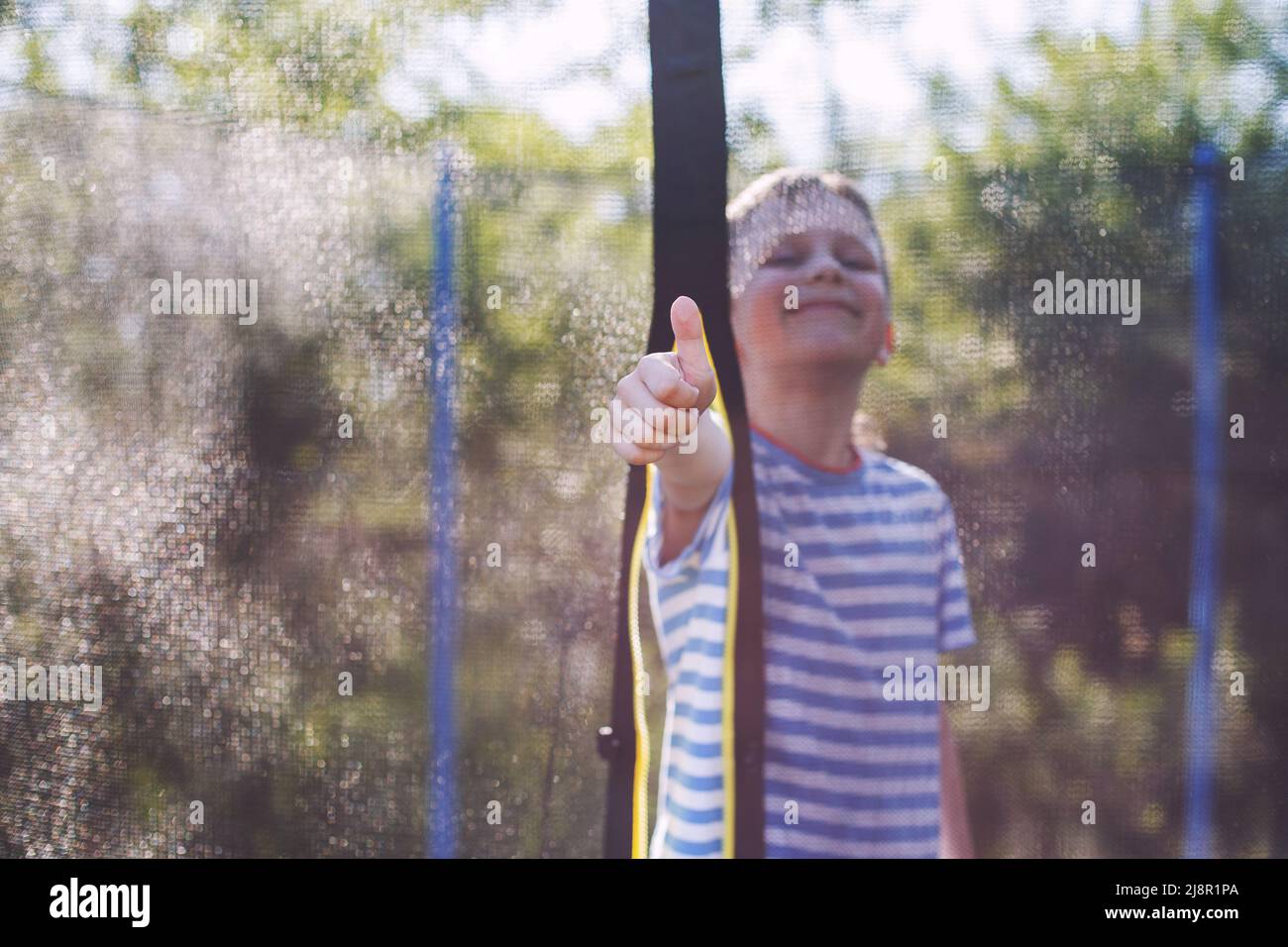 boy jumping on trampoline. child plays and shows thumb up Stock Photo ... boy jumping on trampoline. child plays and shows thumb up Stock Photo ...
