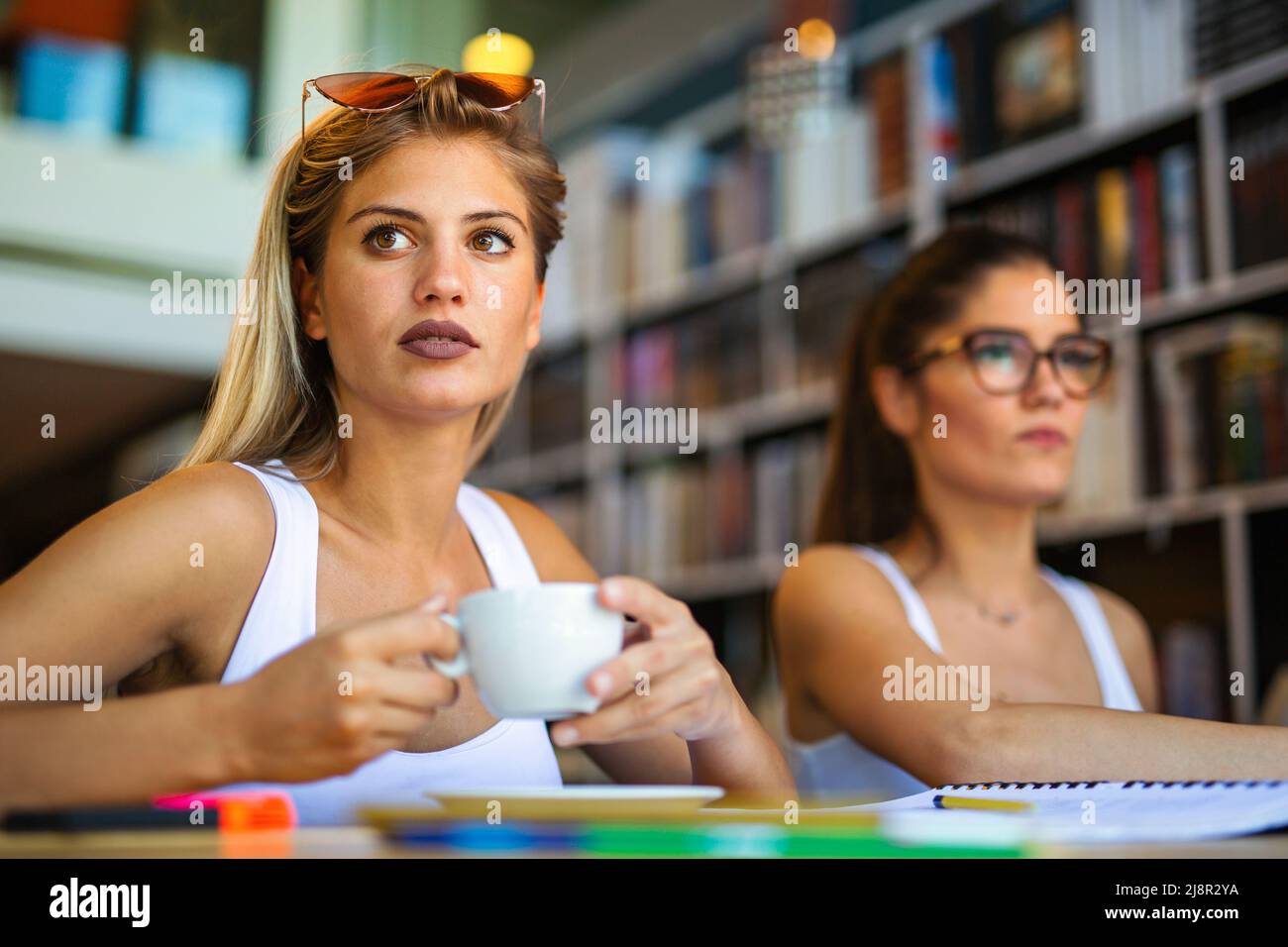 Group of happy college students studying in the school library ...