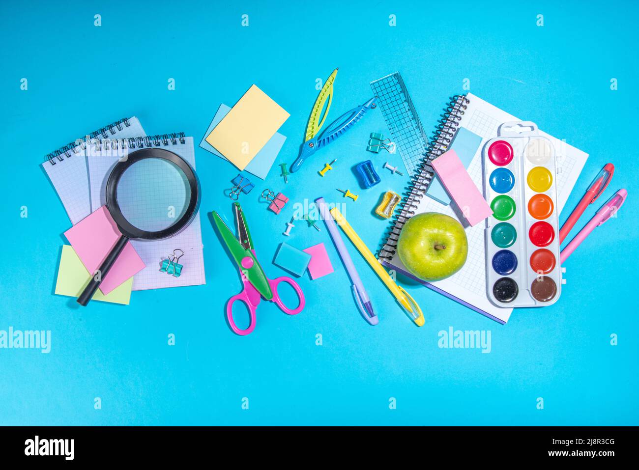 Flat lay background with colorful educational supplies on bright blue ...
