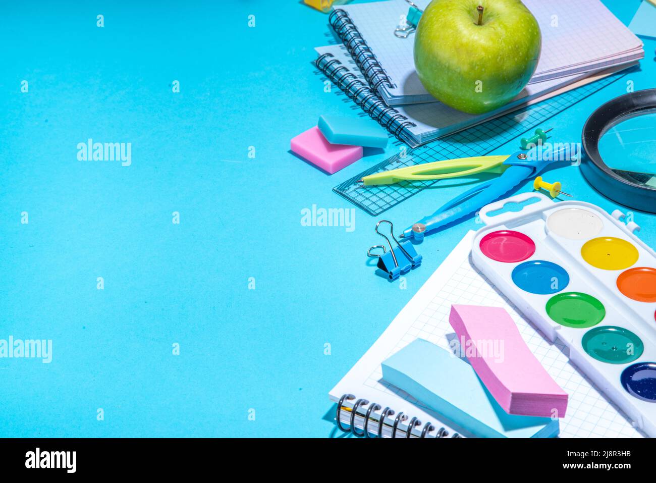 Flat lay background with colorful educational supplies on bright blue ...