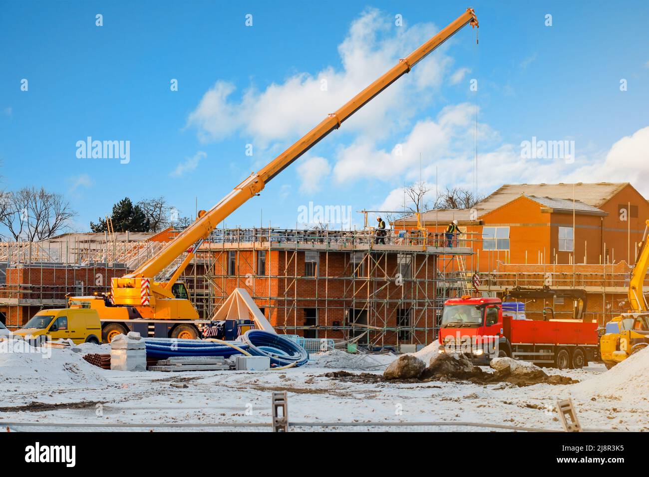 Mobile crane on housing site in wintertime ready for lift during ...