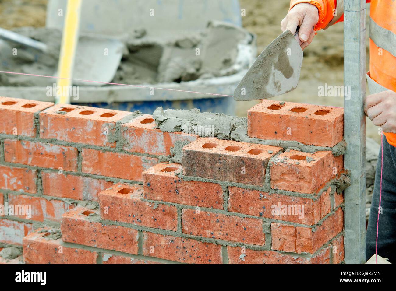 Bricklayer laying bricks on mortar on new residential house ...