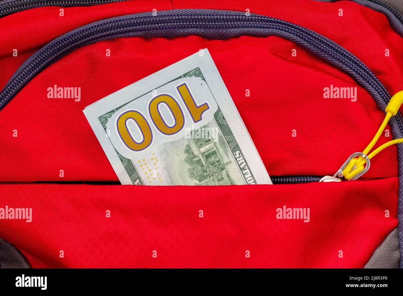One hundred dollar bill in the pocket of the backpack Stock Photo - Alamy