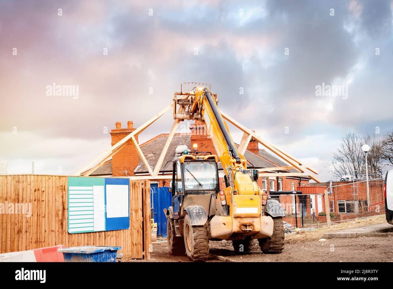 Telehandler moving roof trusses on new housing development building ...