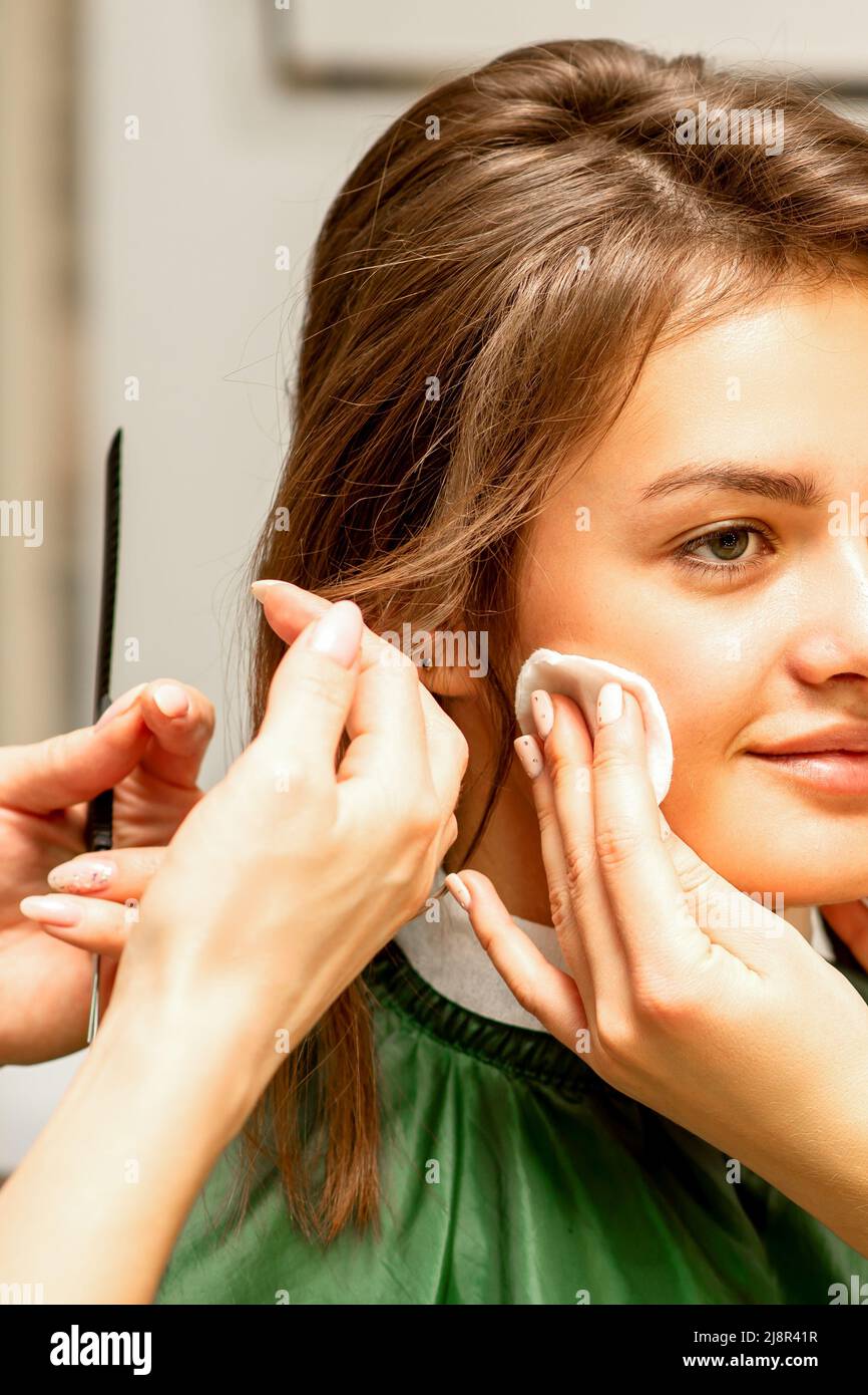 Makeup artist and hairdresser prepare the bride making hairstyle and ...