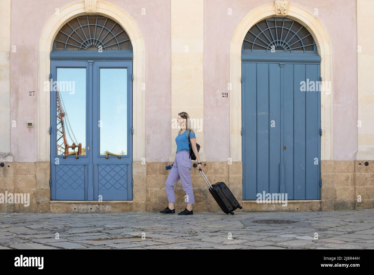 Woman walking between doors hi-res stock photography and images - Alamy