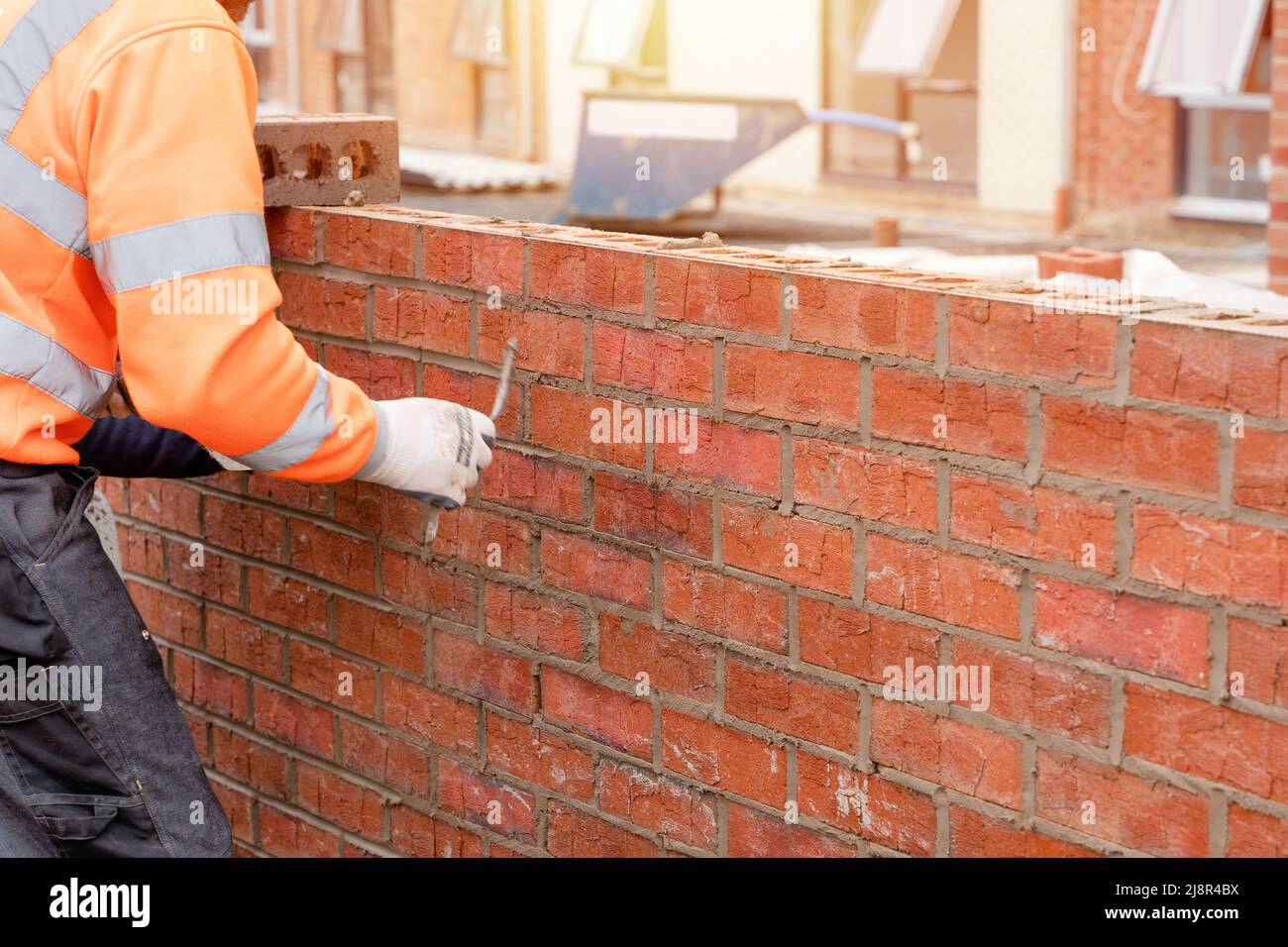 Bricklayer laying bricks on mortar on new residential house ...