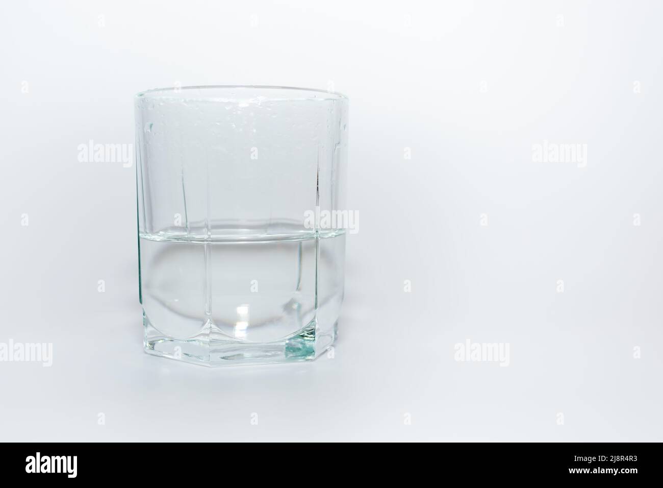 Glass beaker with clean fresh transparent water on a white background ...