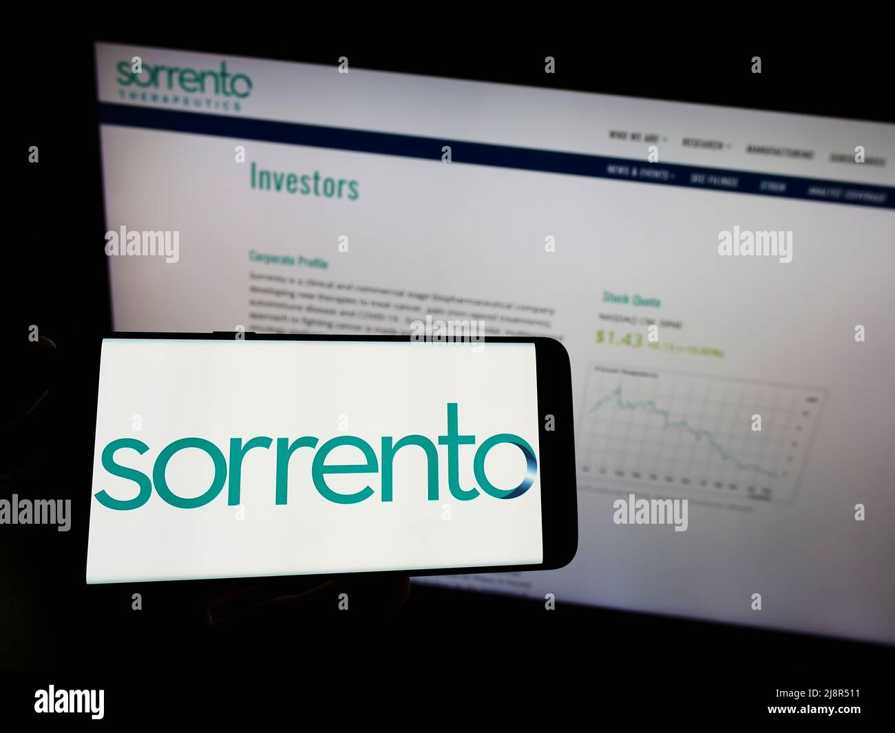 Person holding mobile phone with logo of US biopharma company Sorrento ...