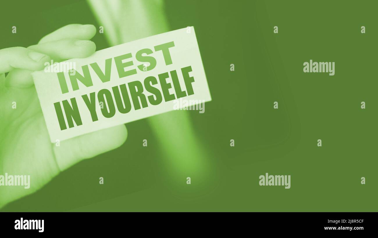 Invest in Yourself message on business card shown by a businessman ...