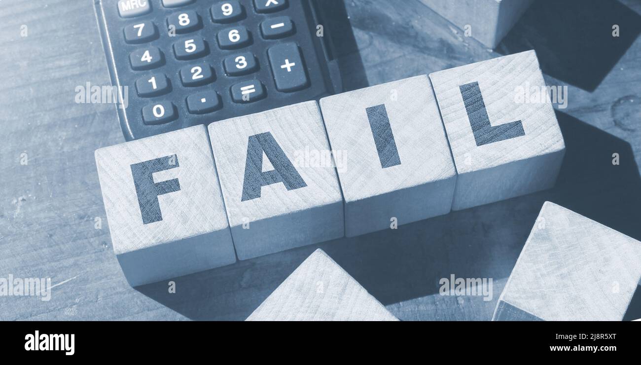 Fail word from wooden blocks and calculator on desk. Business crisis ...