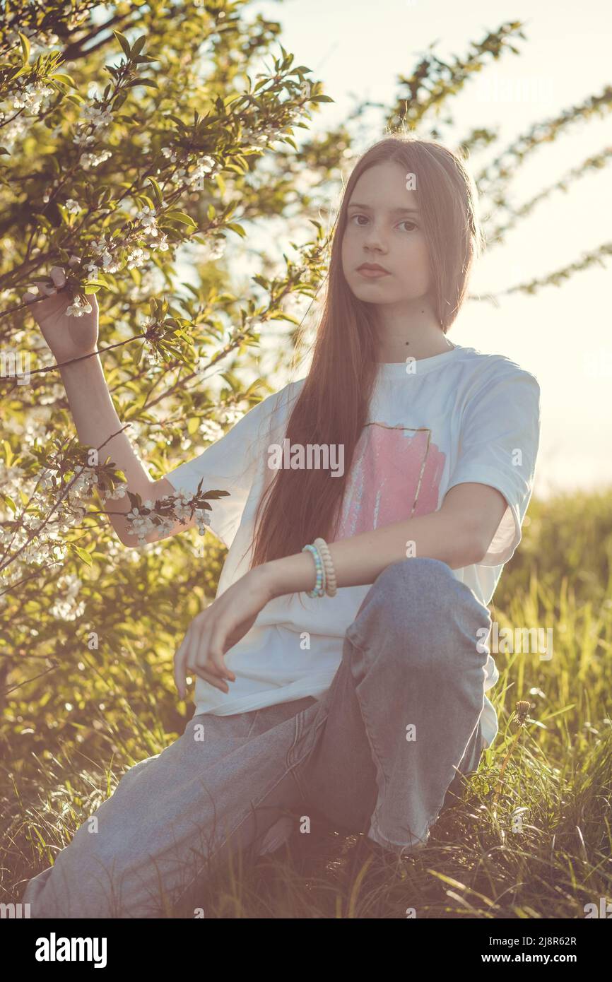Portrait of a beautiful happy teenage girl outdoors in spring. A girl ...