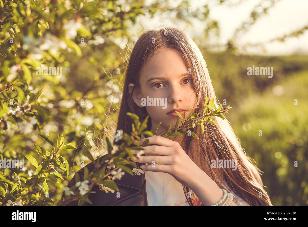 Portrait of a beautiful happy teenage girl outdoors in spring. A girl ...