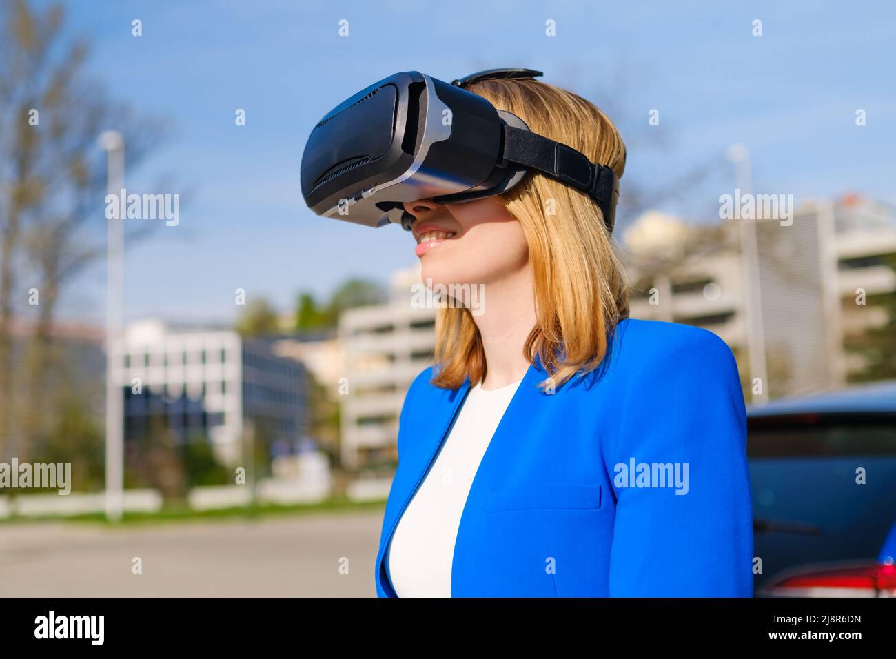 Woman with VR virtual reality goggles experiences a metaverse world ...