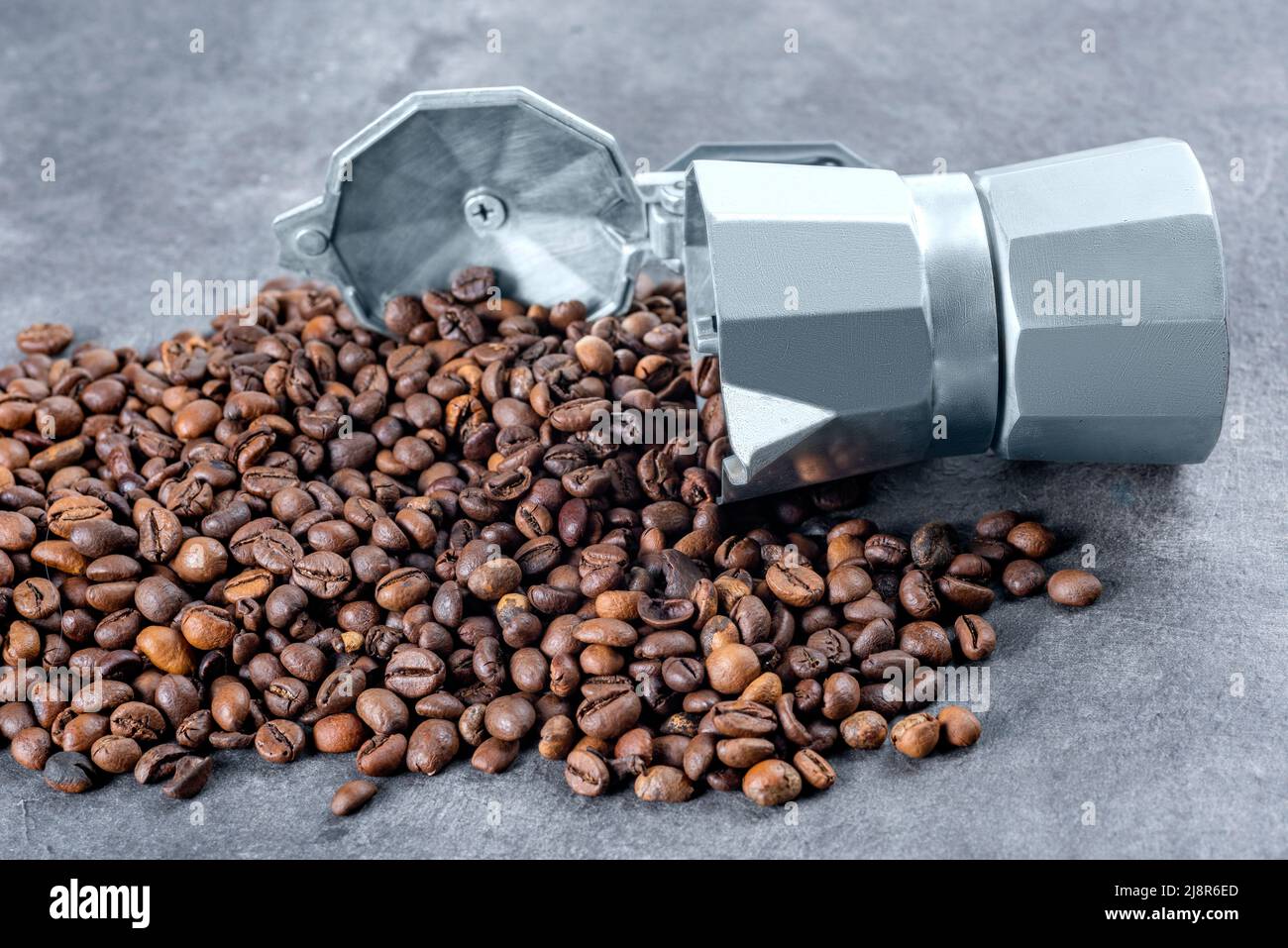 Coffee beans spill from the coffee maker on the textured background ...