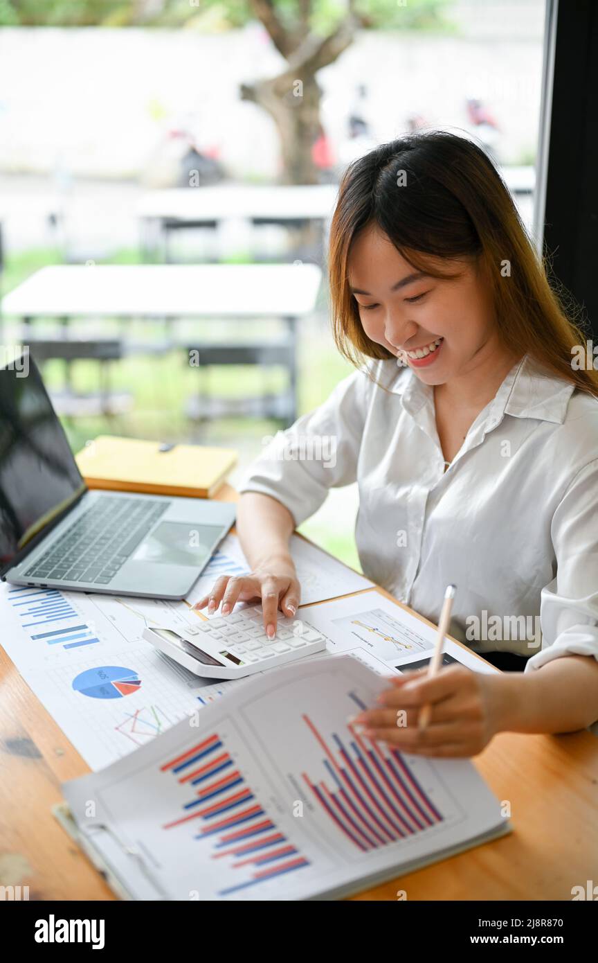 Portrait, Pretty Asian young female financial assistant checking the ...