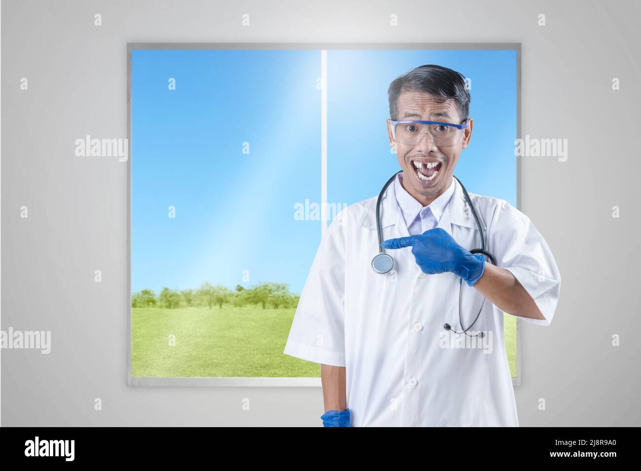 Asian nerd scientist with a stethoscope standing and pointing at ...