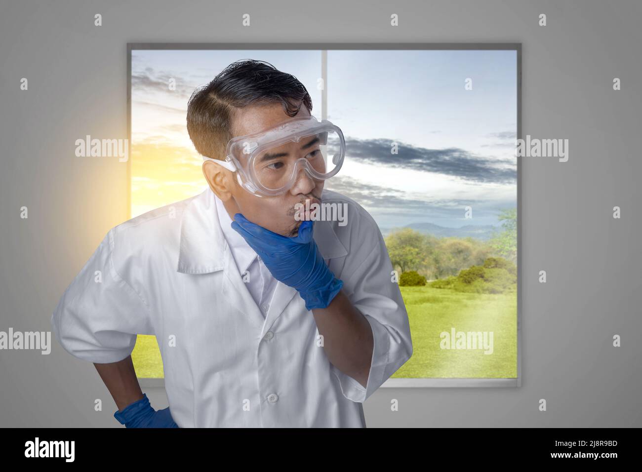 Asian nerd scientist standing and thinking something with a window ...