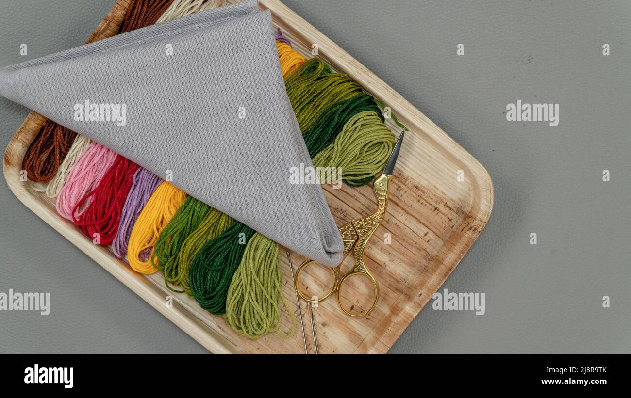Preparations for embroidery with gray and multi-colored floss thread ...