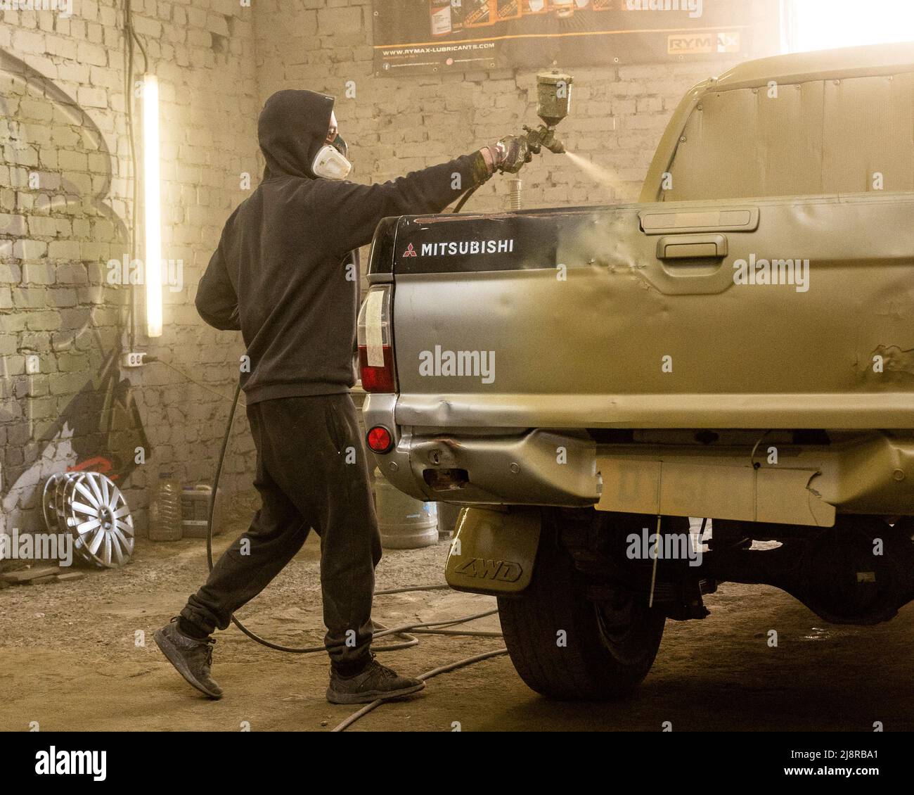 A donated vehicle being painted green for the Ukrainian army. (Photo by ...