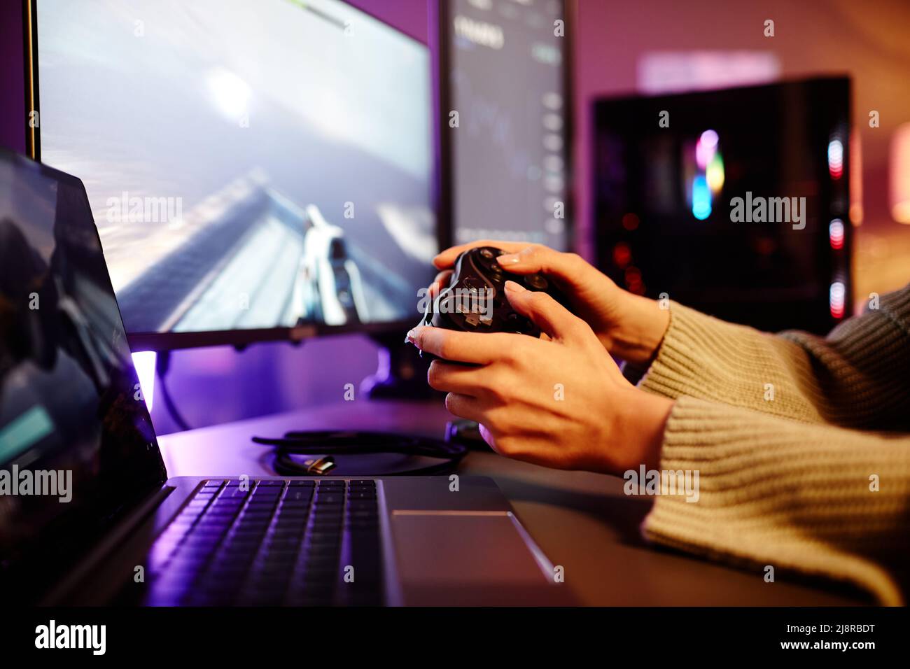 Unrecognizable woman sitting at desk with computer and laptop on it ...