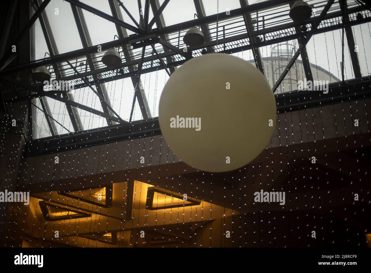 Ball hangs from ceiling. Large sphere against background of transparent ...