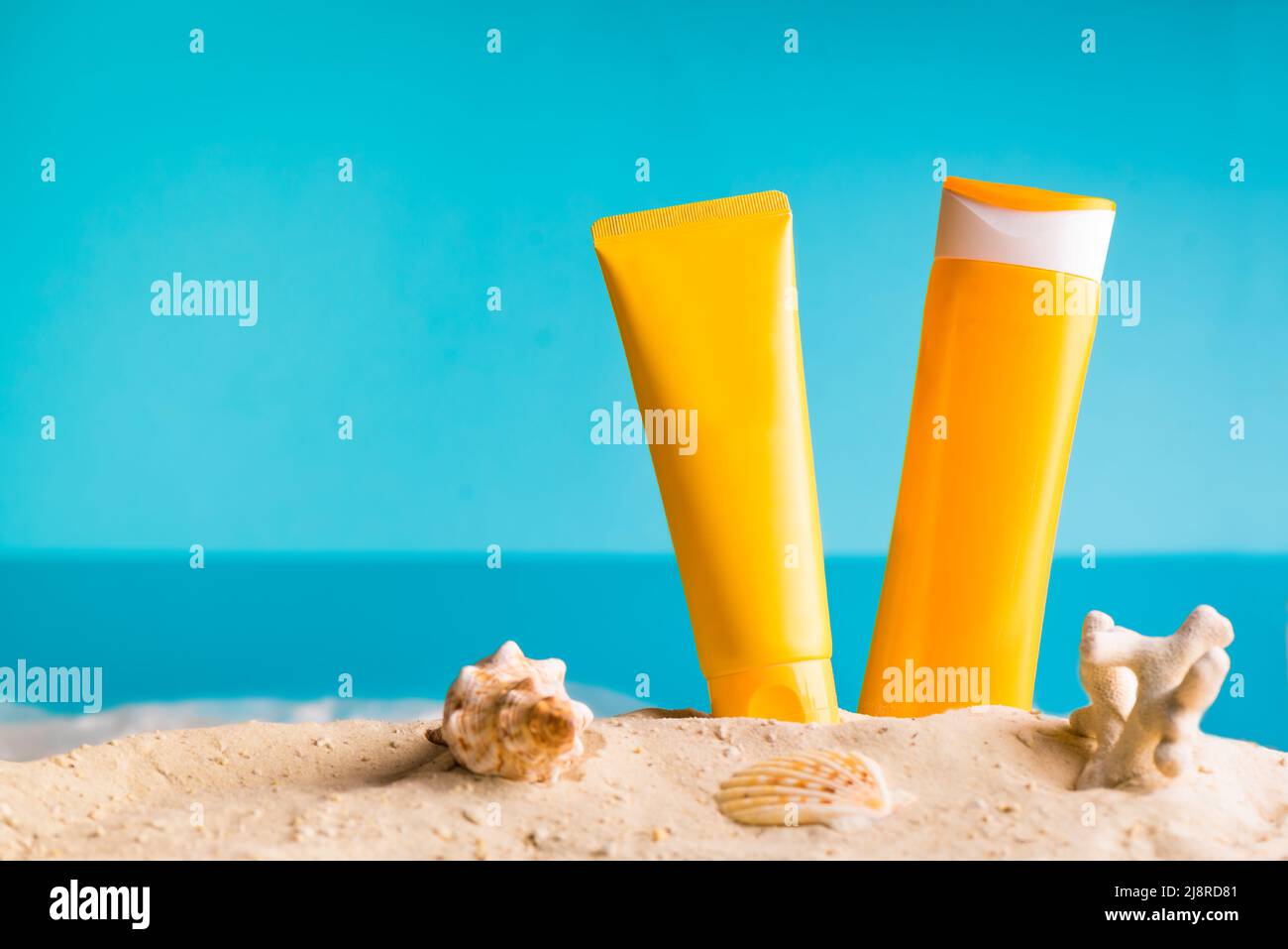 Sunscreen lotion on sandy beach, blue sea as background, copy space ...