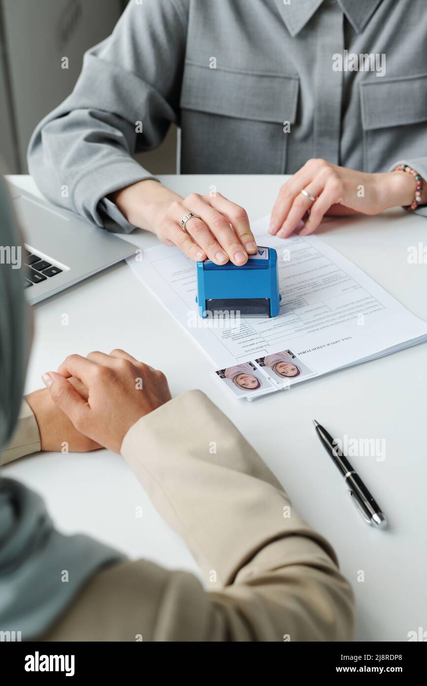 Vertical high angle of unrecognizable Muslim woman waiting for consular ...