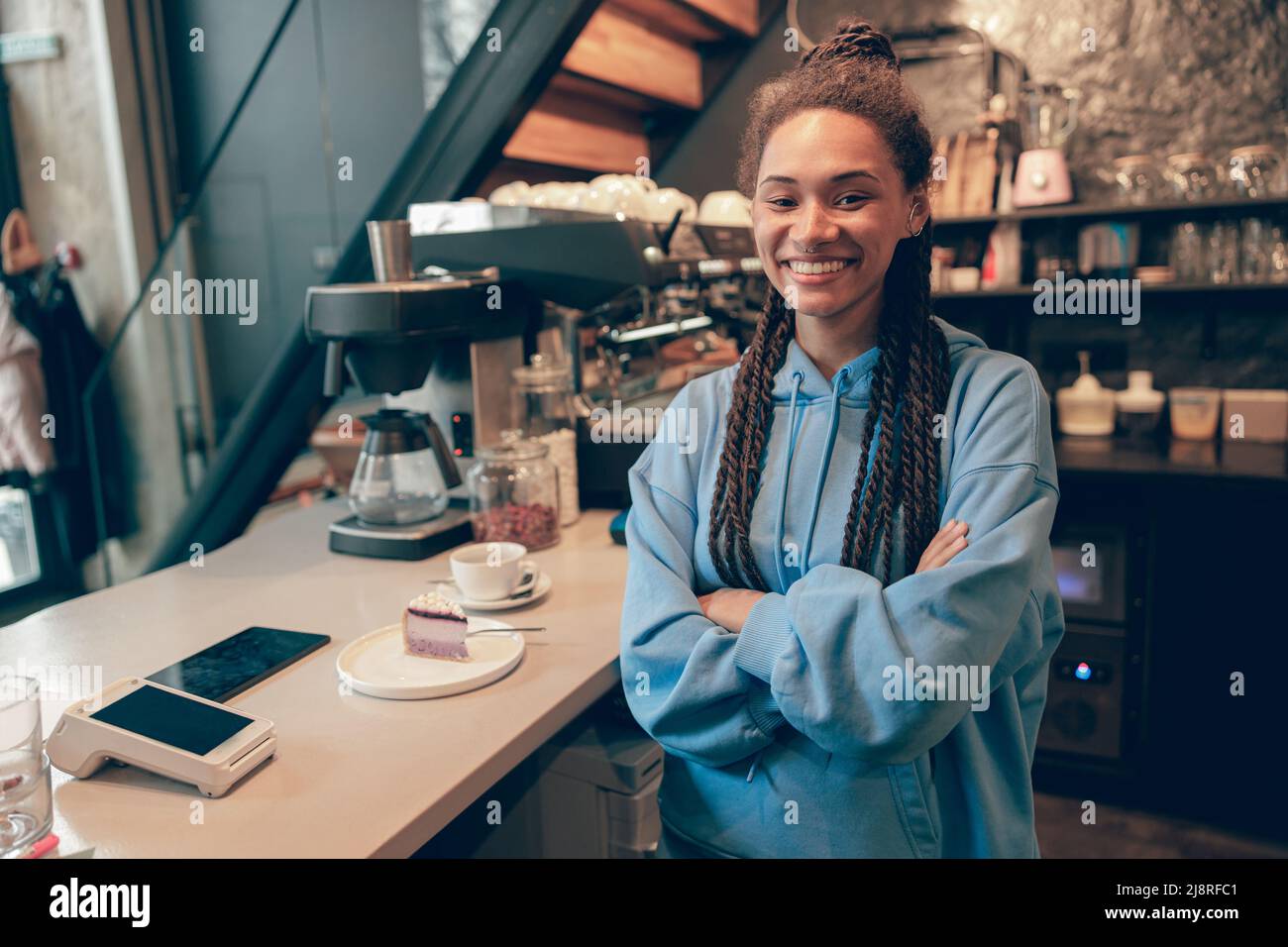 Beautiful young happy stylish female barista standing and smiling at ...