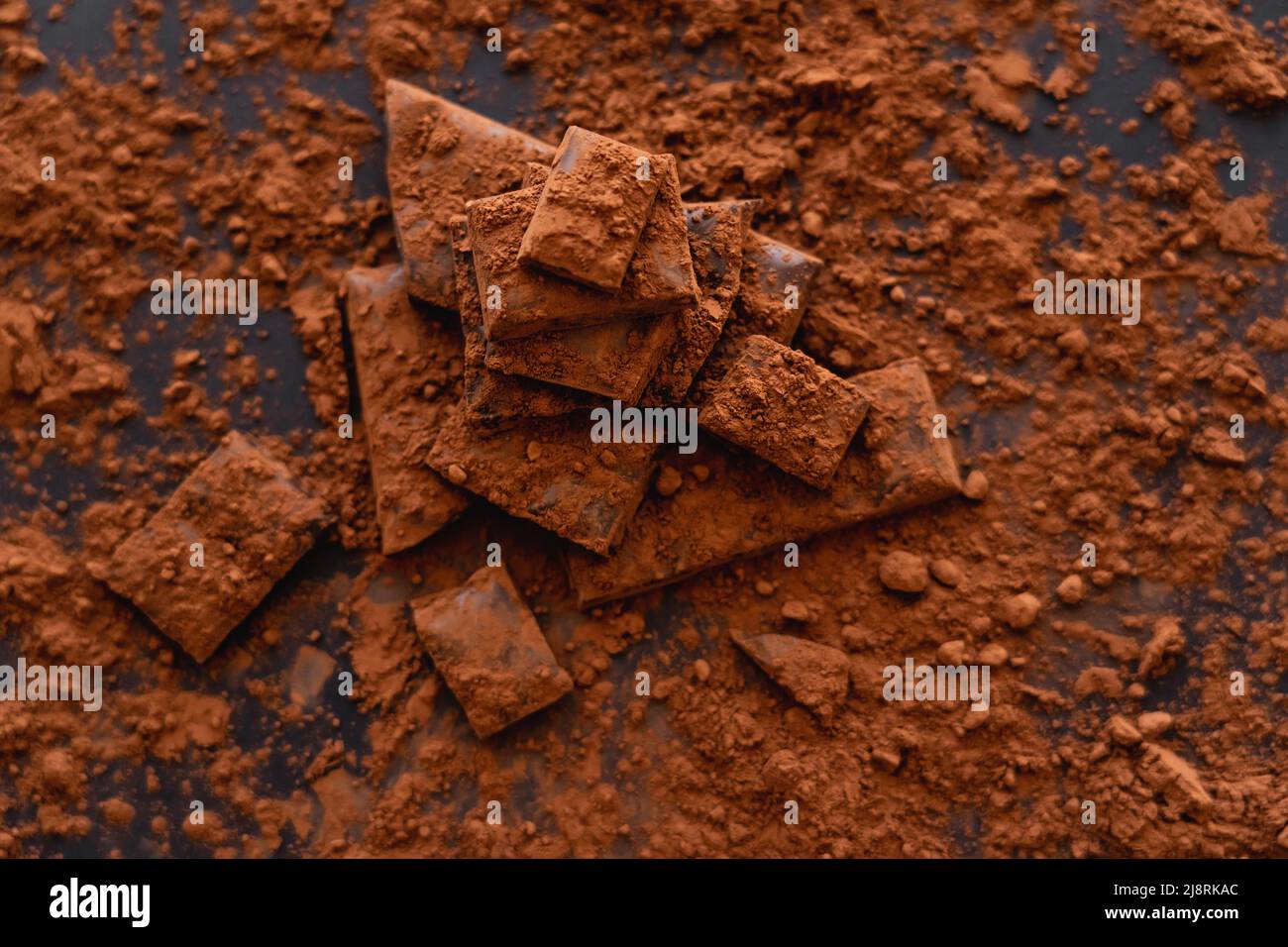 Top view of dry cocoa on chocolate pieces on black background Stock ...