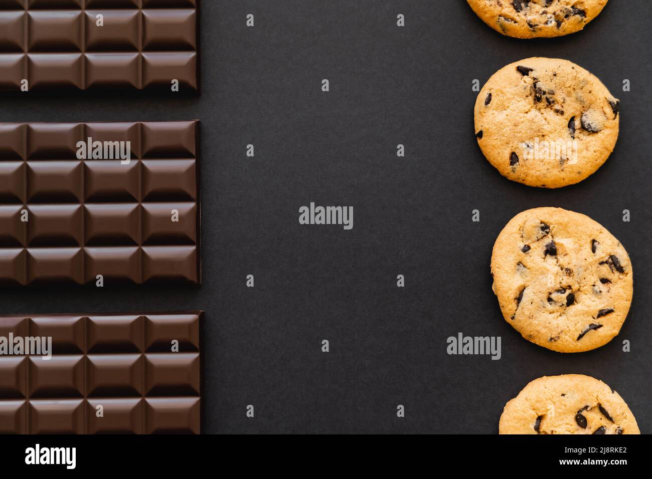 Flat lay with chocolate bars and cookies on black background Stock ...